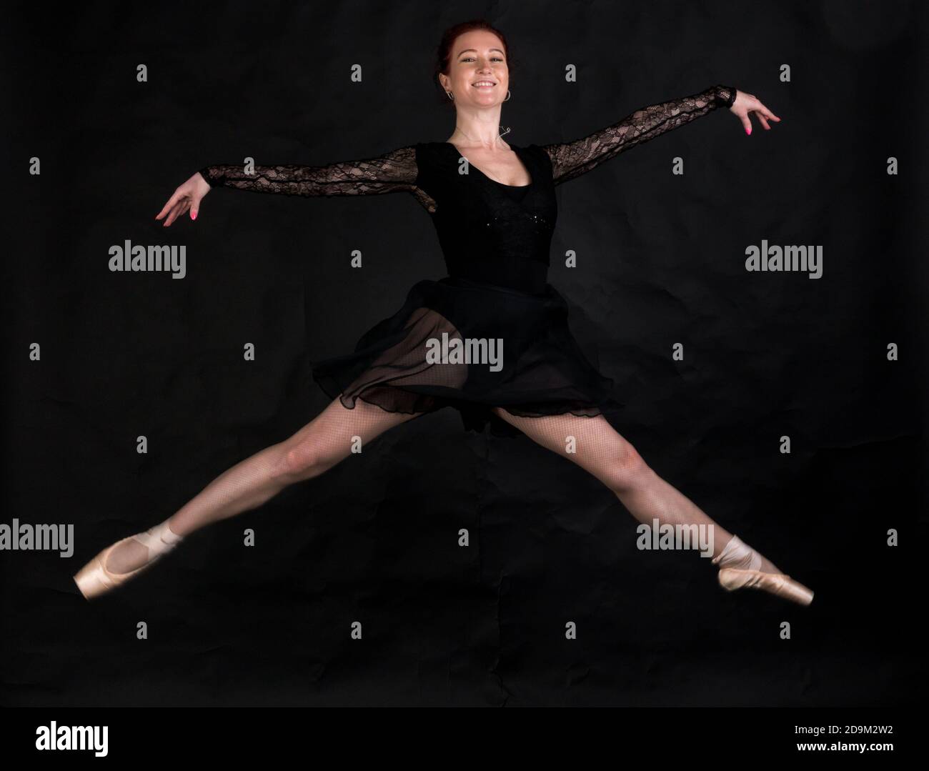 Beautiful dancer studio portrait jumping on black background Stock ...