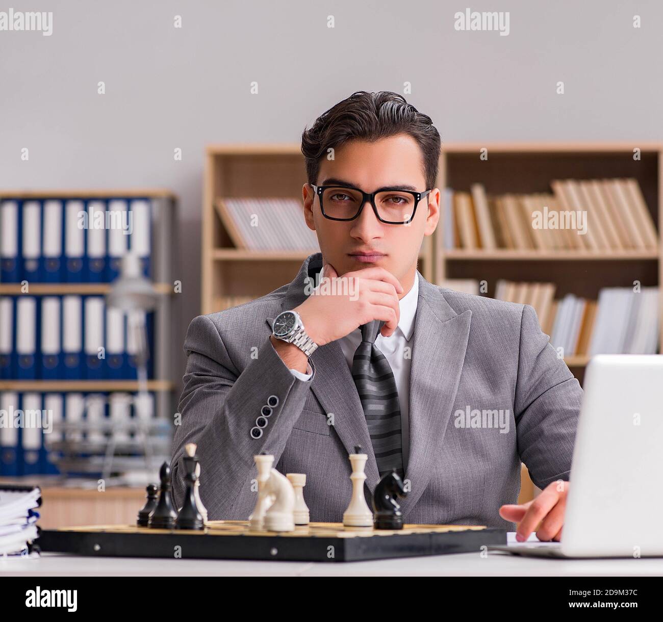 The young businessman playing chess in the office Stock Photo - Alamy