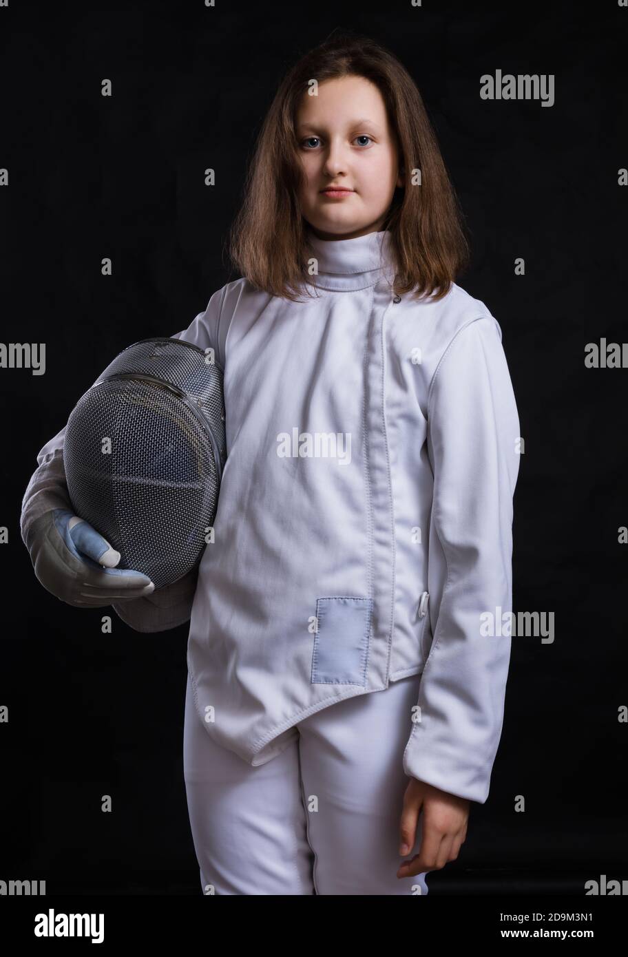Teenage girl fencer dressed in uniform with epee and helmet studio ...