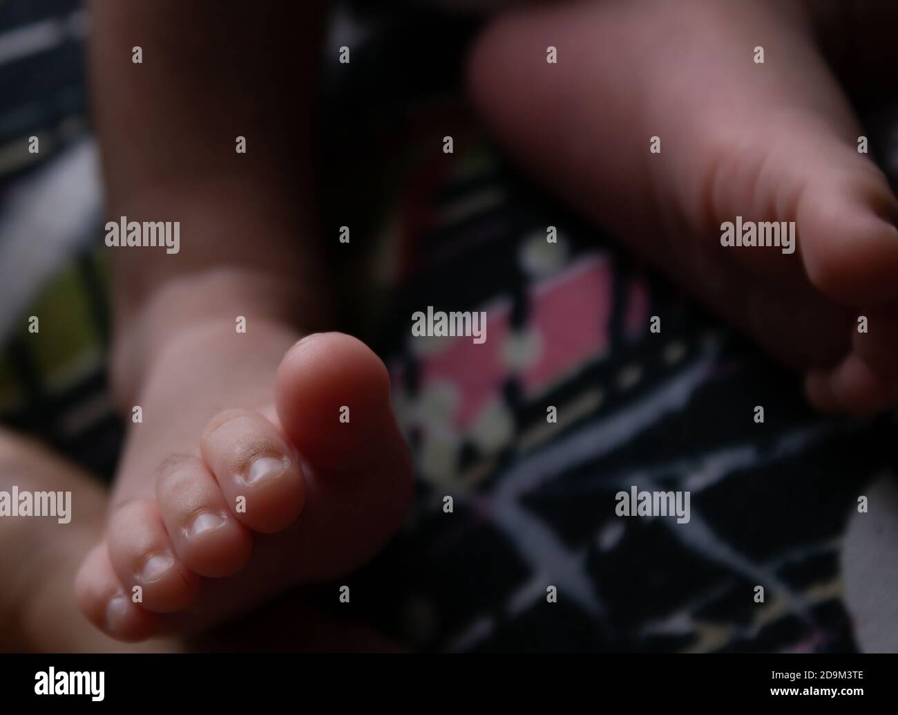 newborn baby feet in bed focused in finger nails of a indian new born ...