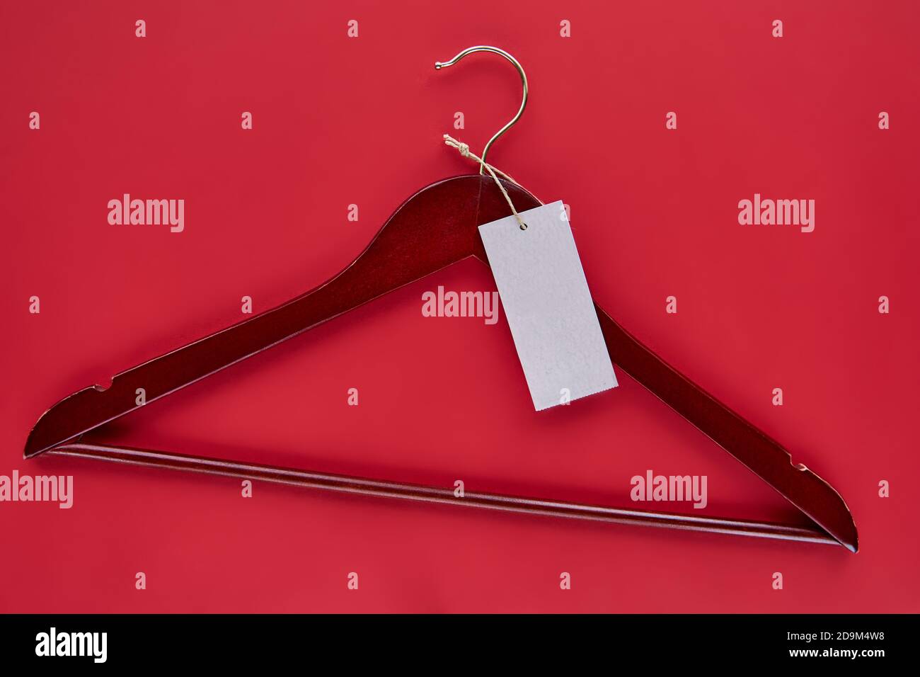 Wooden red hanger with black paper label isolated on red paper ...