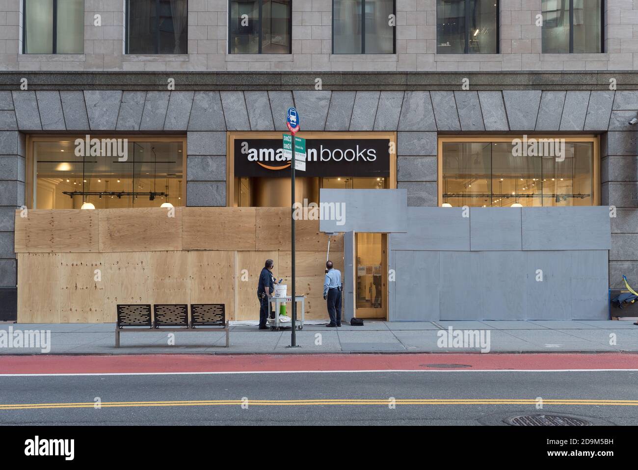 Two people boarding up an Amazon book store in Midtown Stock Photo - Alamy