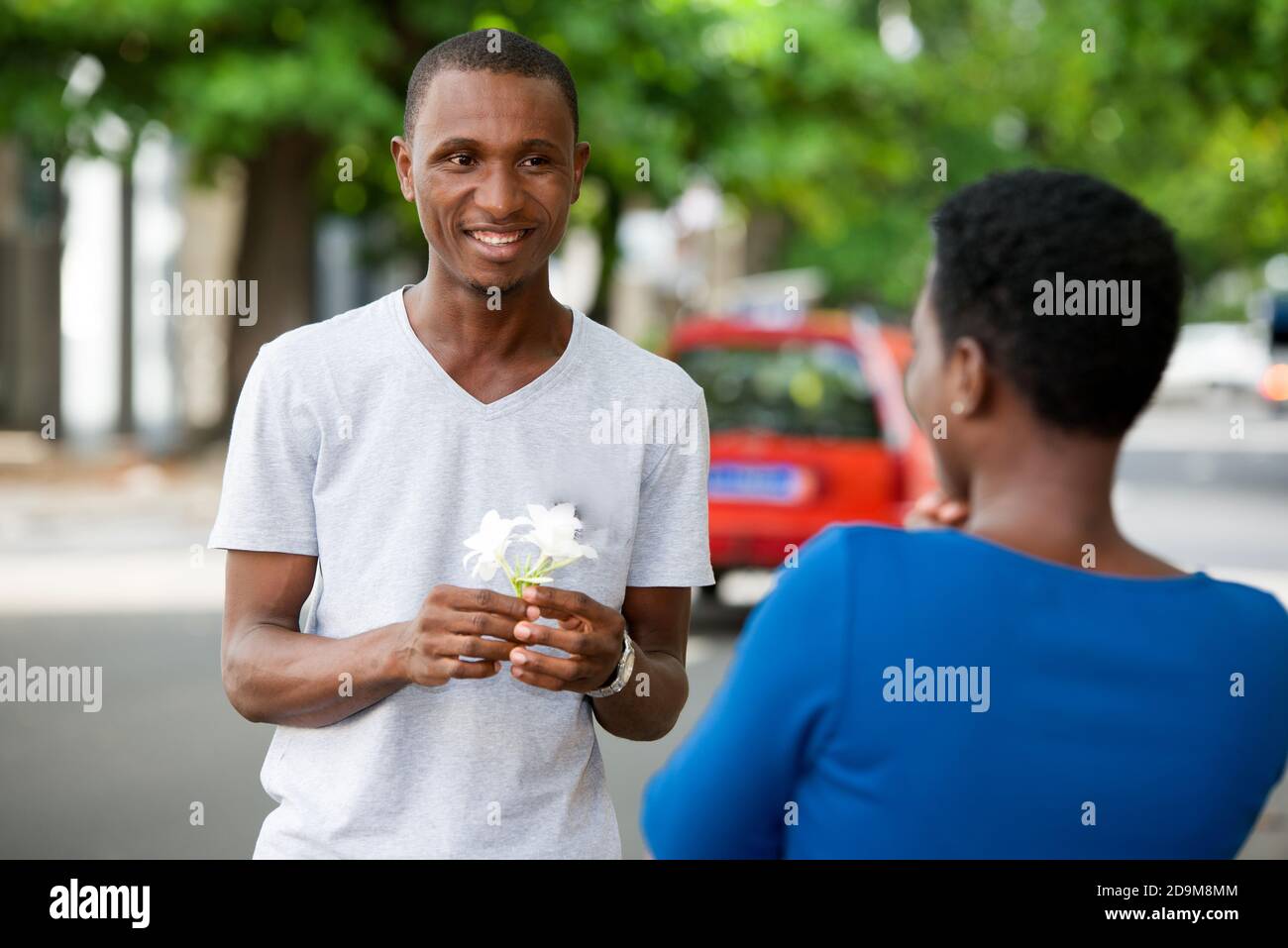 Young people standing face to face are looking at each other smiling ...