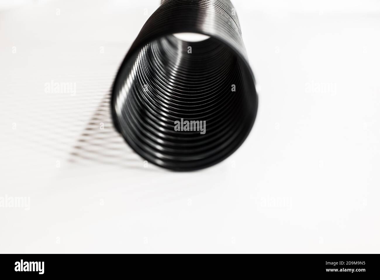 black plastic coil spring on white background Stock Photo - Alamy