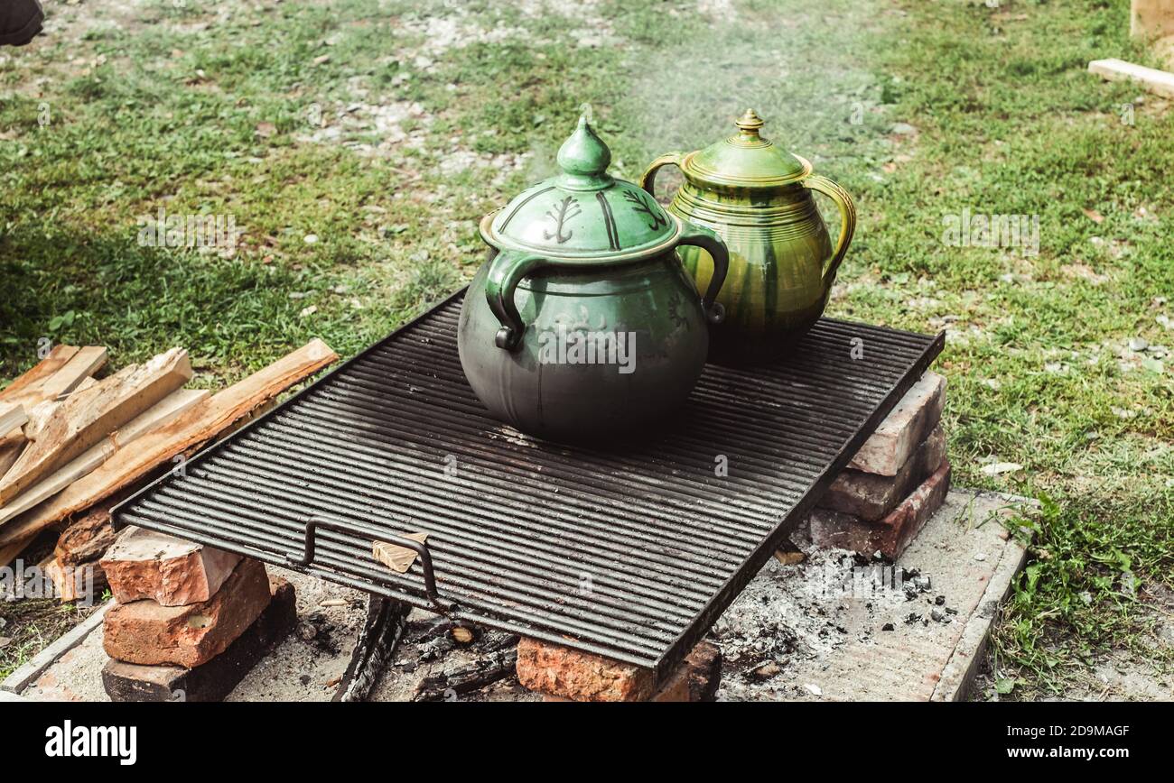 preparing Romanian traditional food in clay dishes an open fire Stock ...
