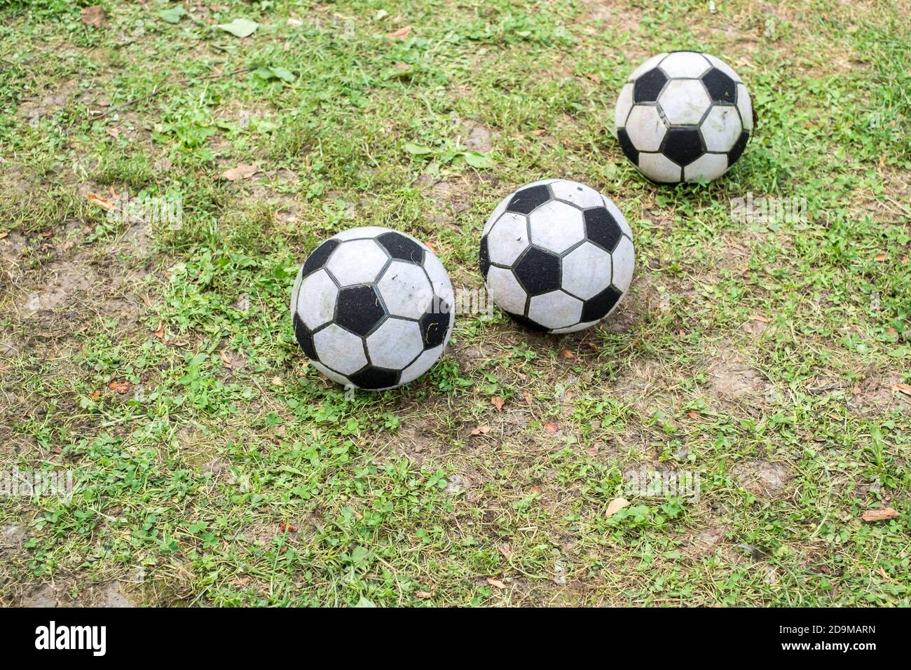 three soccer balls in the grass Stock Photo - Alamy