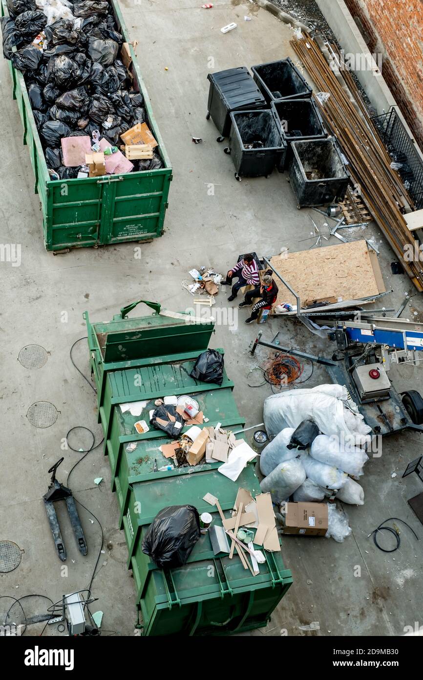 two people between garbage containers Stock Photo - Alamy