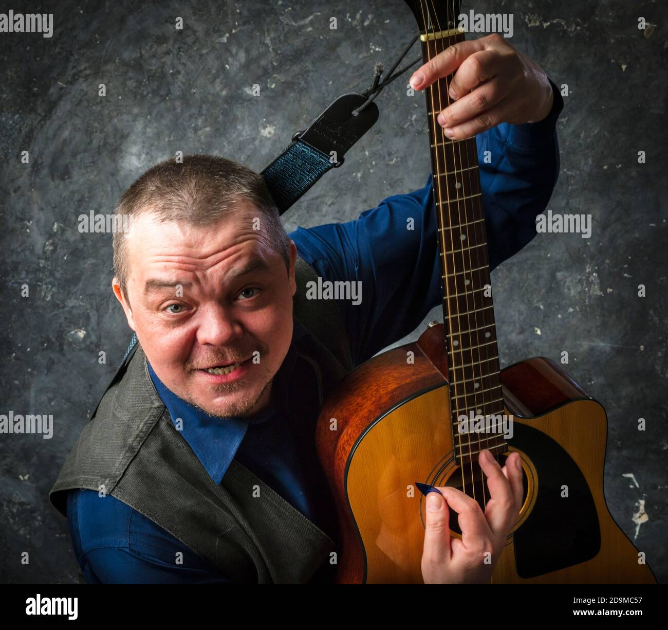 Mature musician plays acoustic guitar emotional studio portrait Stock ...