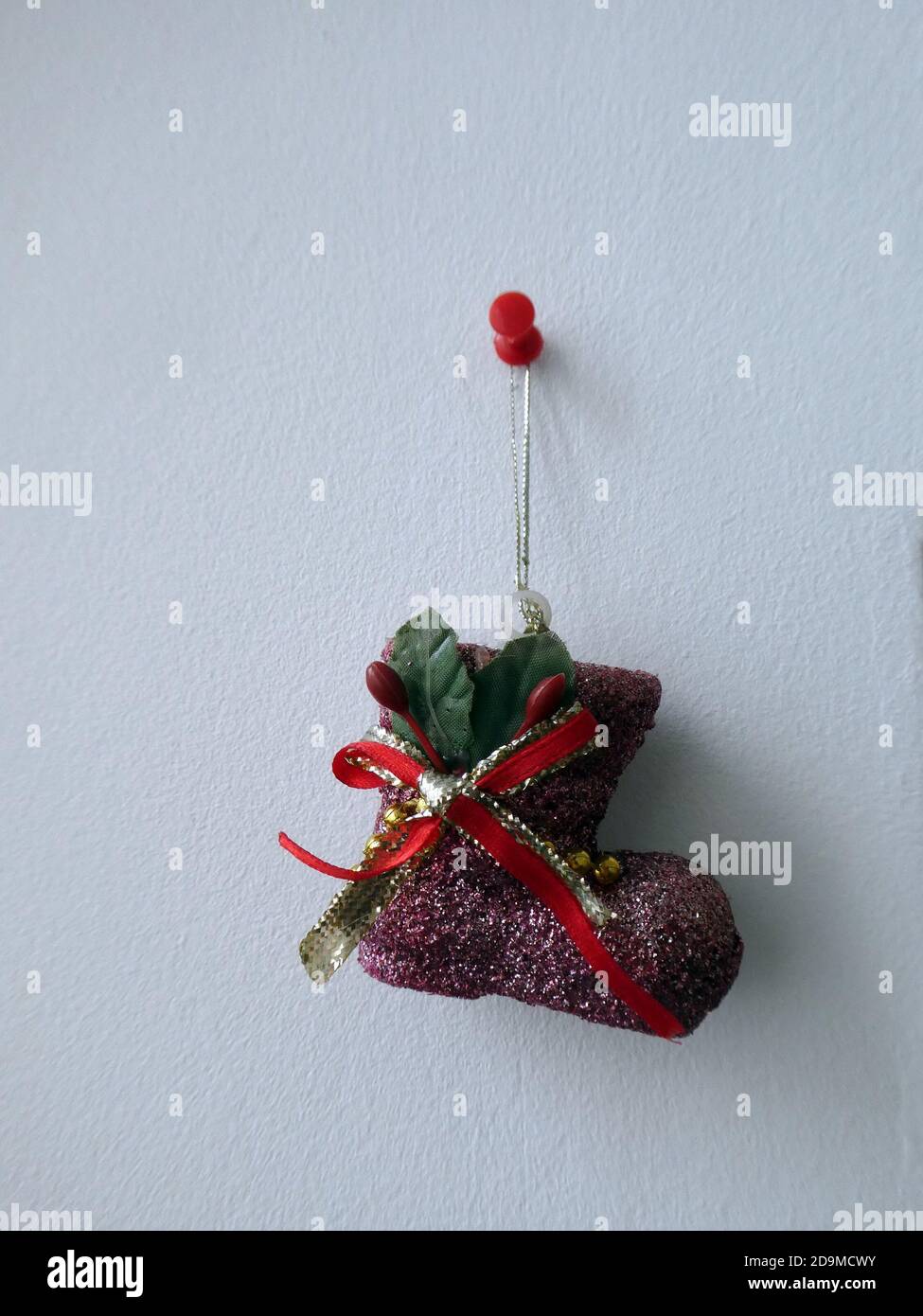 Decorative boot with red ribbon hanging on the wall for christmas Stock ...