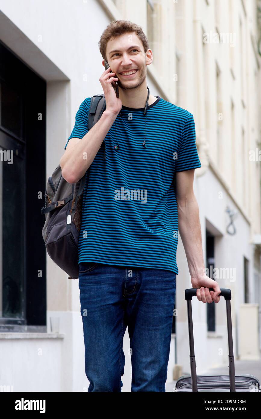 Portrait young travel man walking and talking with mobile phone and ...