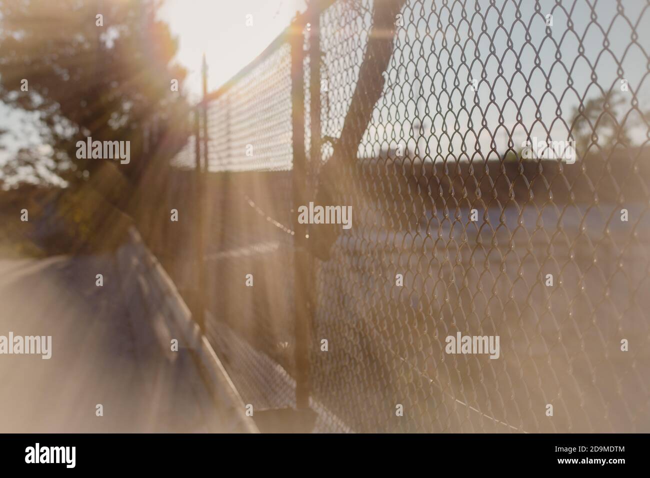 Close up of chain link fence with sun flare Stock Photo - Alamy