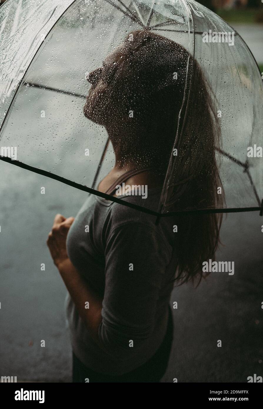 Woman holding an umbrella looking up at the sky on a rainy day Stock ...