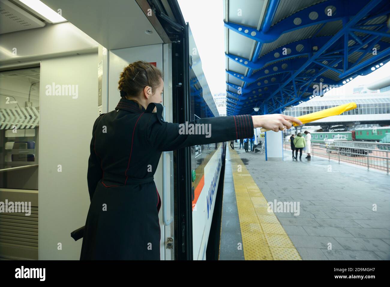 Female train conductor signaling departure of the passenger train ...