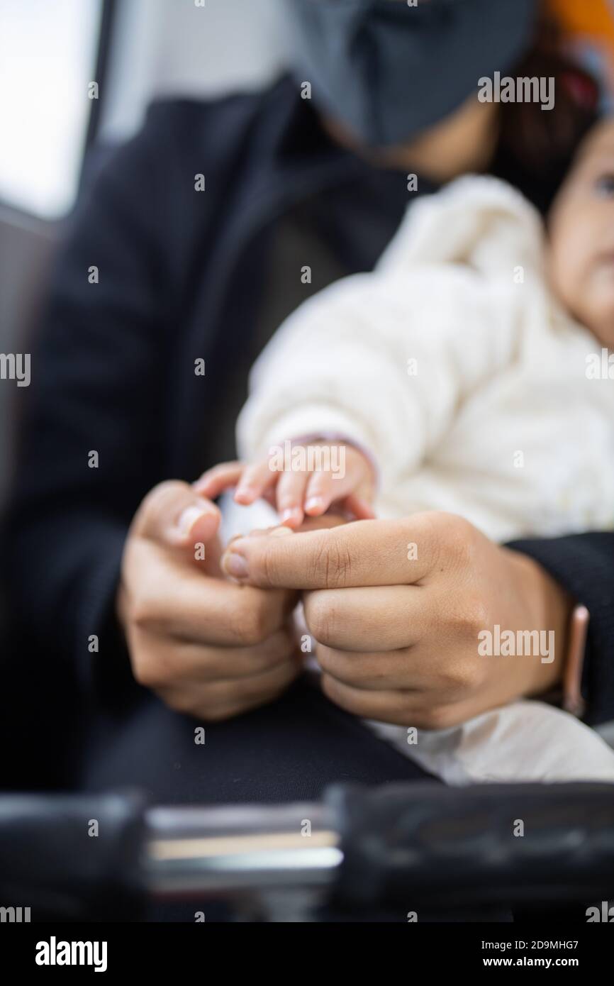 Close up view of the little hand of a baby reaching the hands of her ...