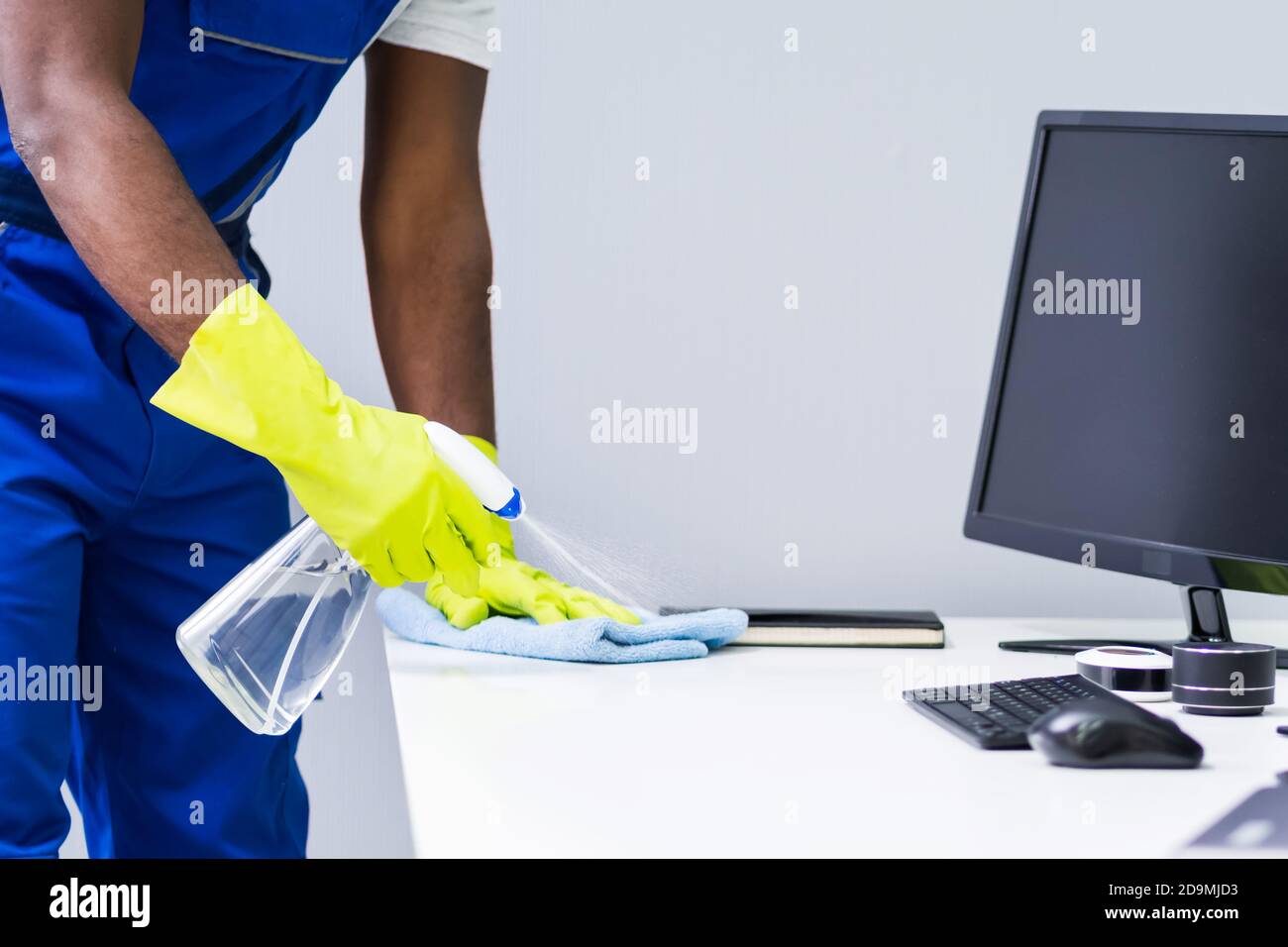 African American Man Cleaning Office Computer Desk Stock Photo - Alamy