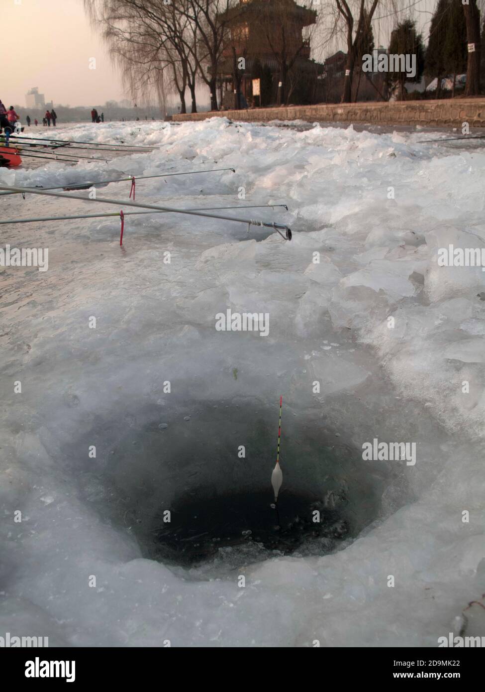 Fishing through the ice on a frozen lake Stock Photo - Alamy