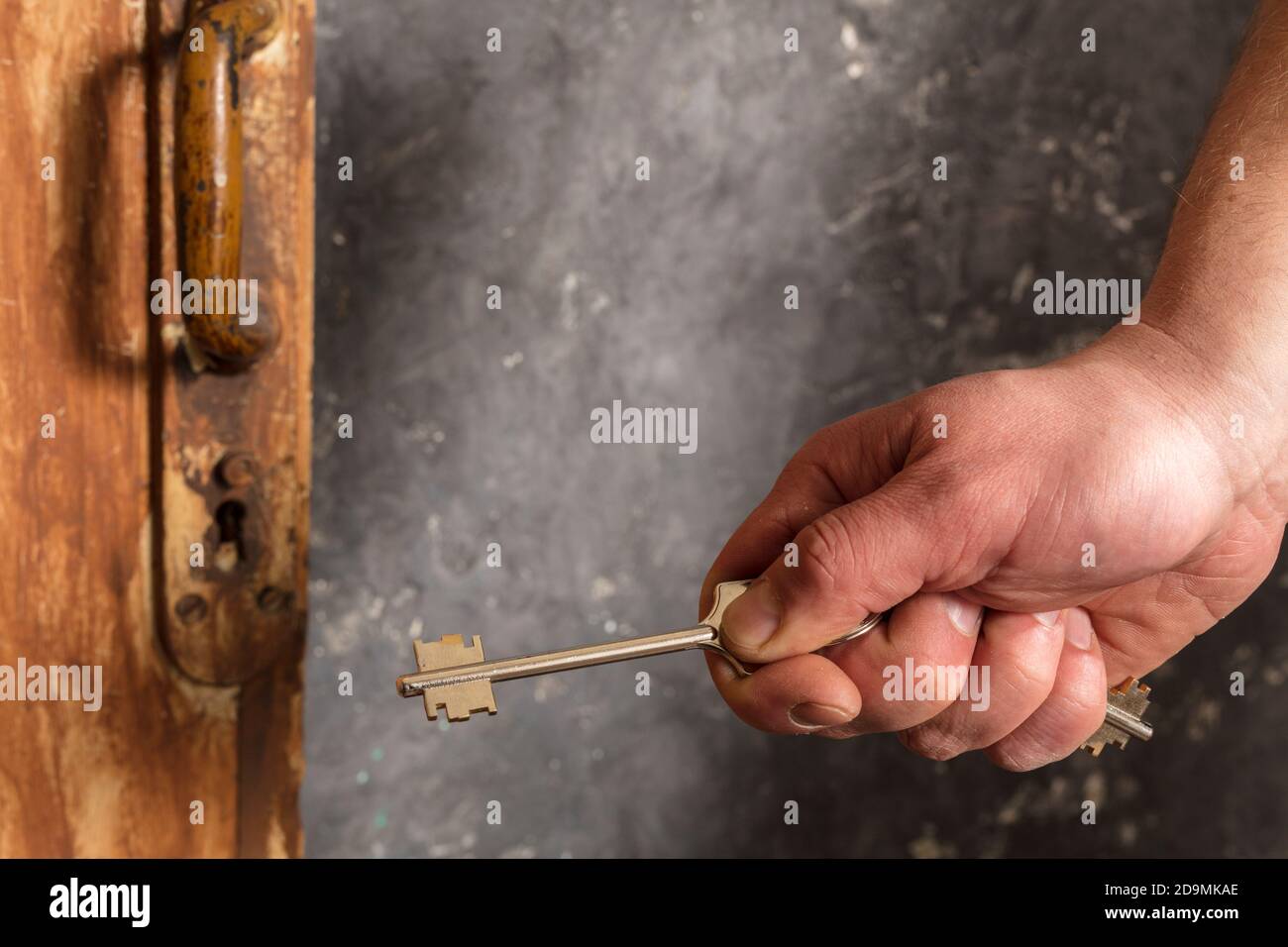 Hand with vintage key and keyhole close up view studio shot Stock Photo ...