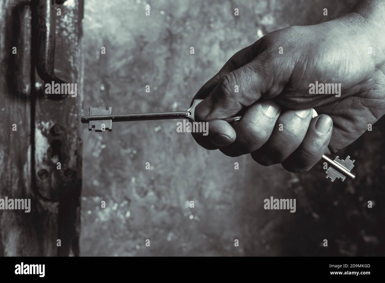 Hand with vintage key and keyhole close up view studio shot Stock Photo ...