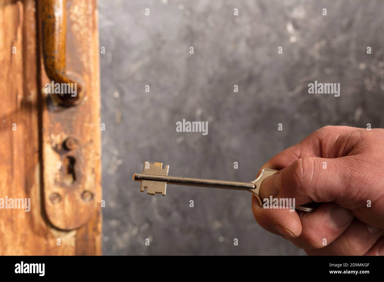 Hand with vintage key and keyhole close up view studio shot Stock Photo ...