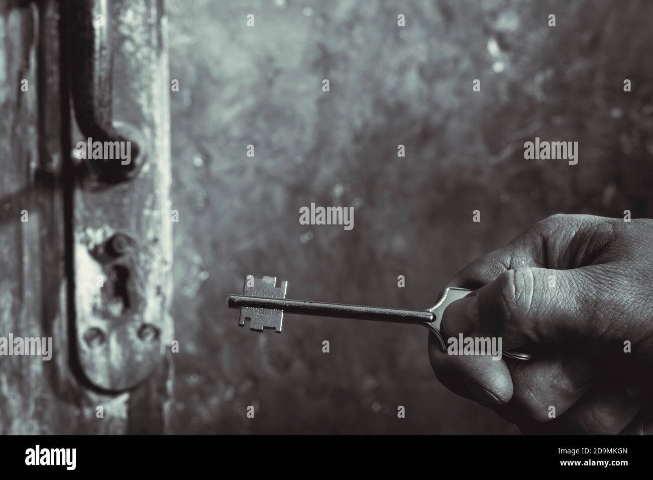 Hand with vintage key and keyhole close up view studio shot Stock Photo ...
