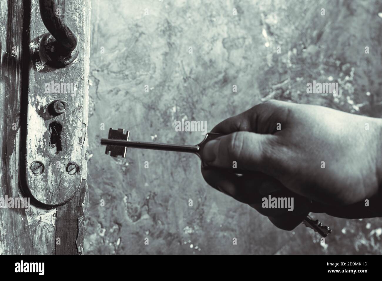 Hand with vintage key and keyhole close up view studio shot Stock Photo ...