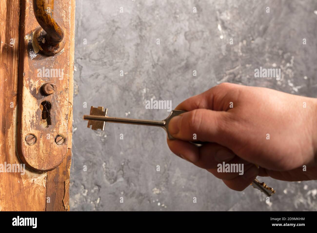 Hand with vintage key and keyhole close up view studio shot Stock Photo ...