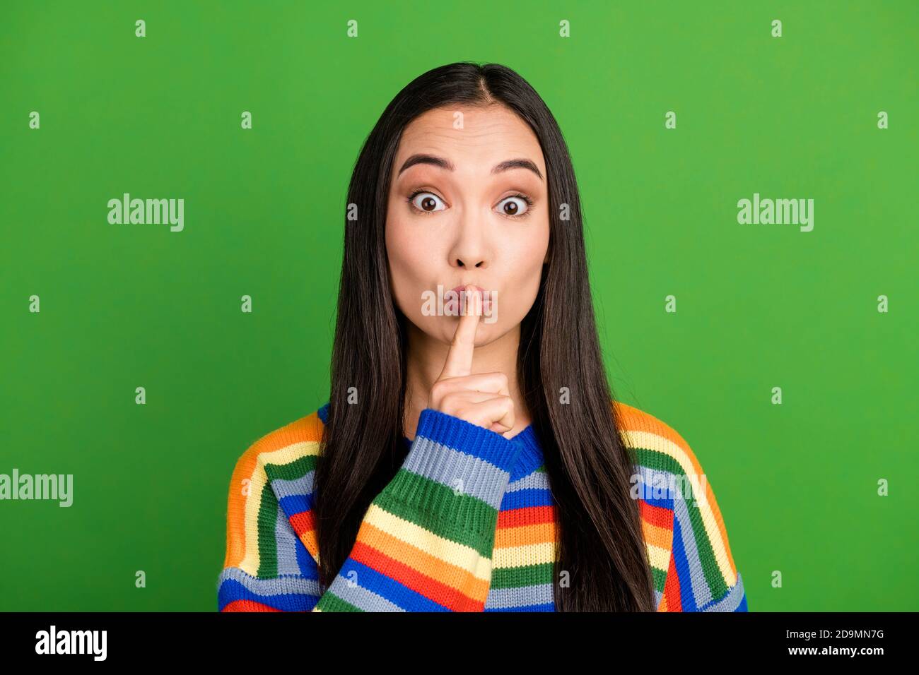 Close-up portrait of attractive mysterious girl showing shh sign keep ...