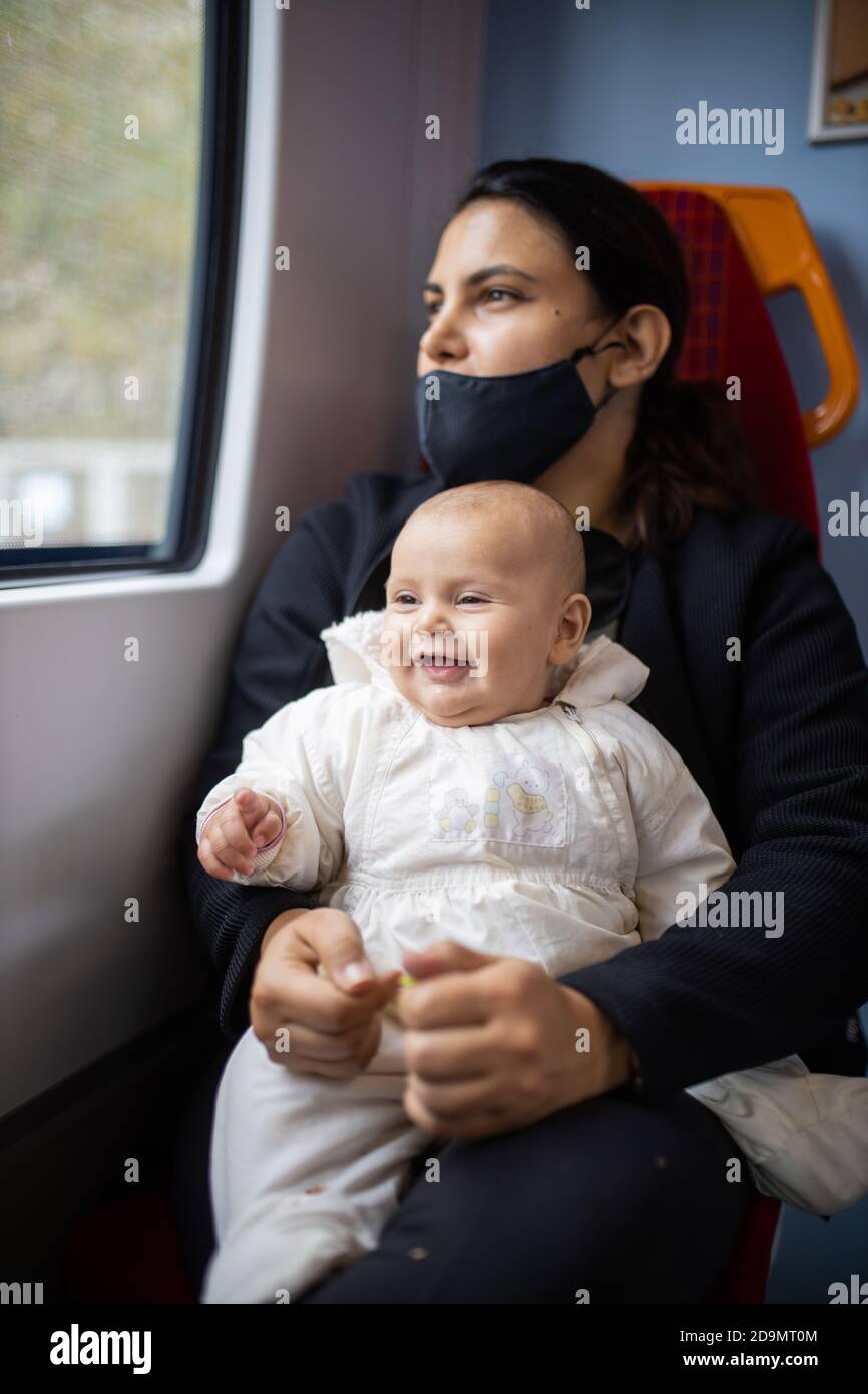 Woman looking through the window of a bus and holding her smiling happy ...