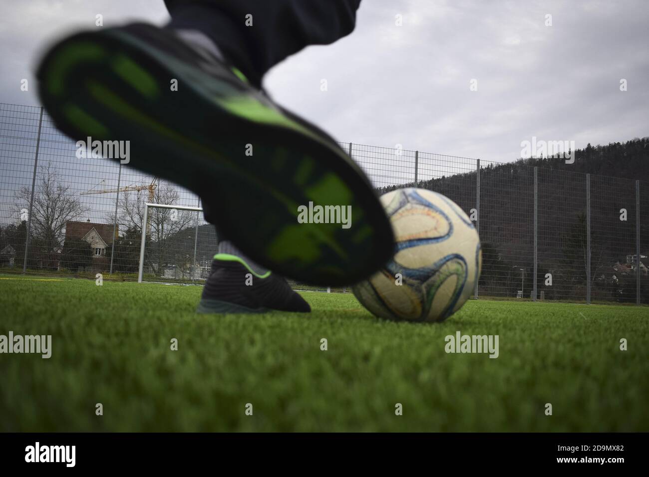 Selective focus shot of a male playing with the ball on a football ...