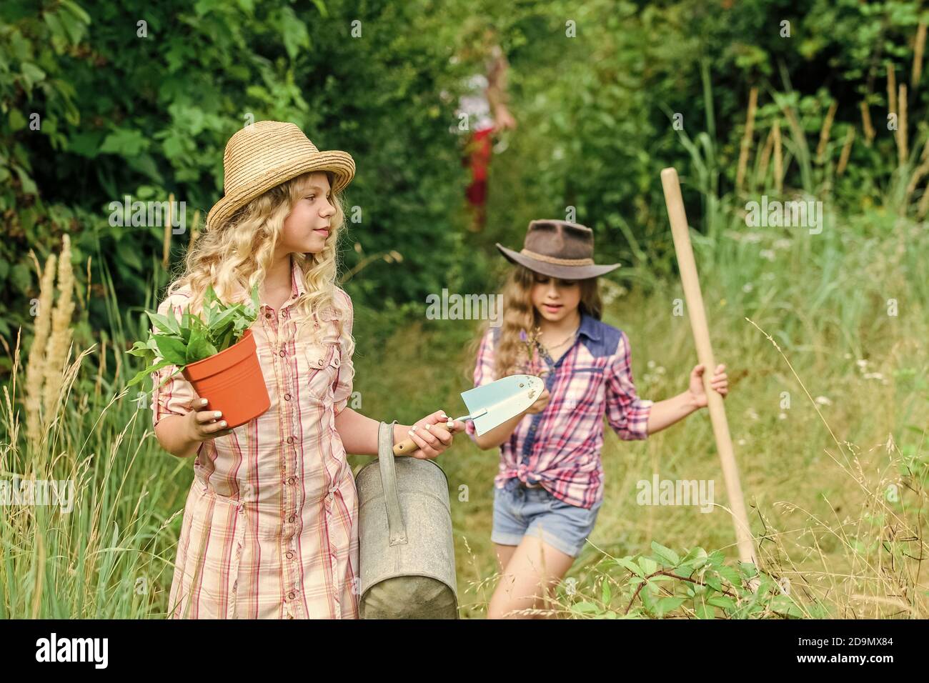 Sisters helping at farm. Girls with gardening tools. Eco farming ...