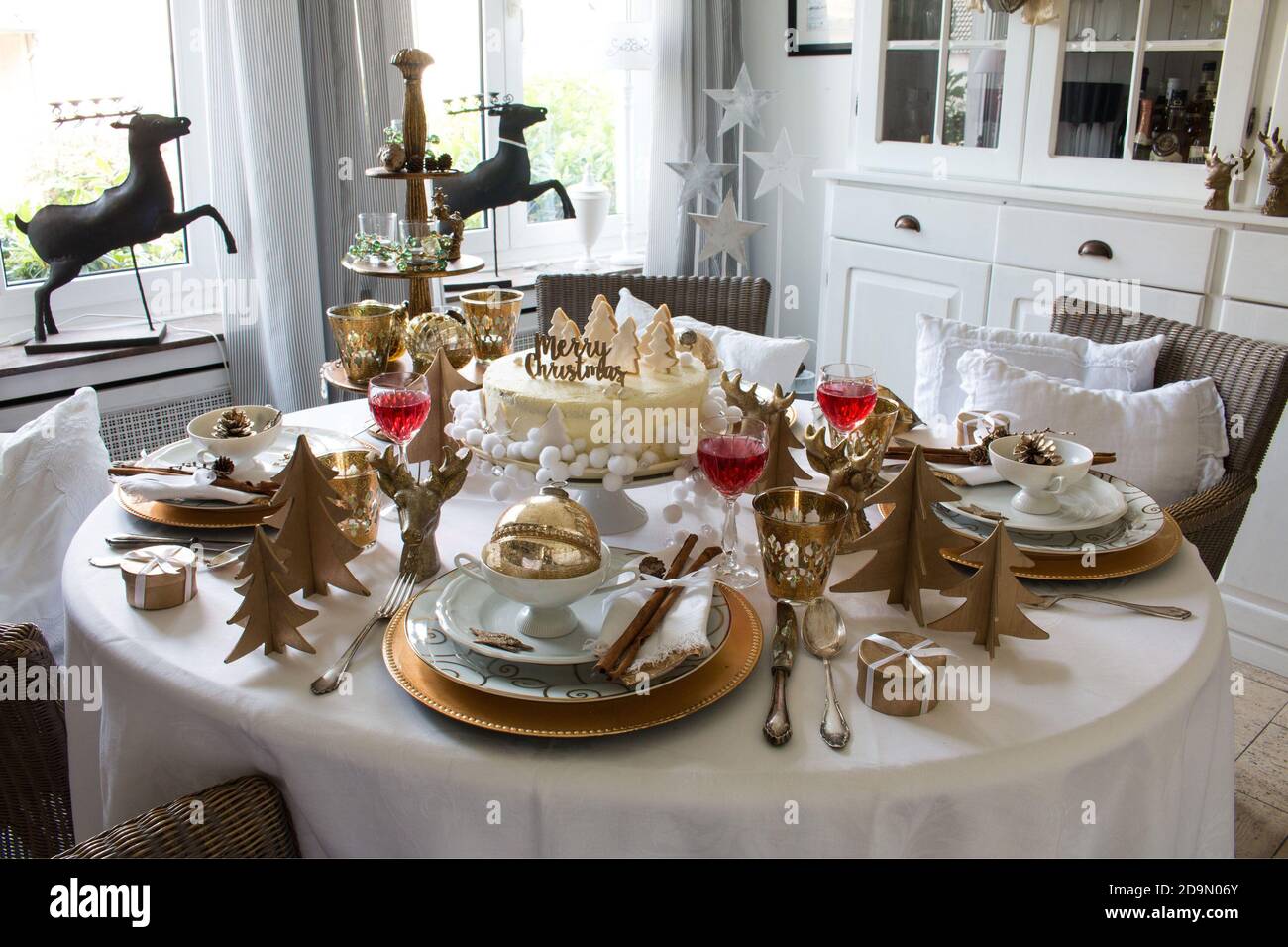 Round table with Christmas cake and decorated setting Stock Photo - Alamy