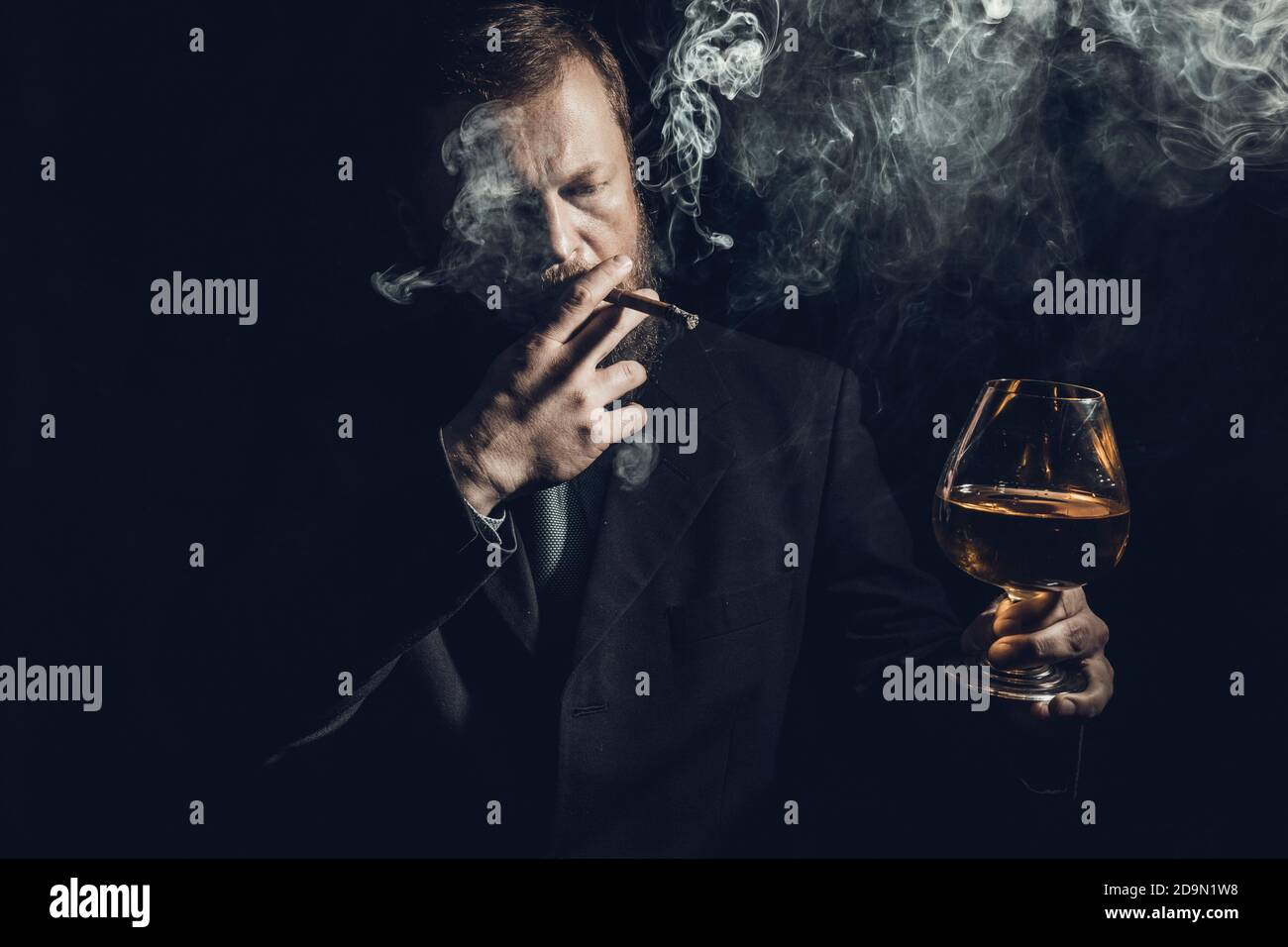 Solid confident bearded man in suit with glass of whisky and cigar with ...