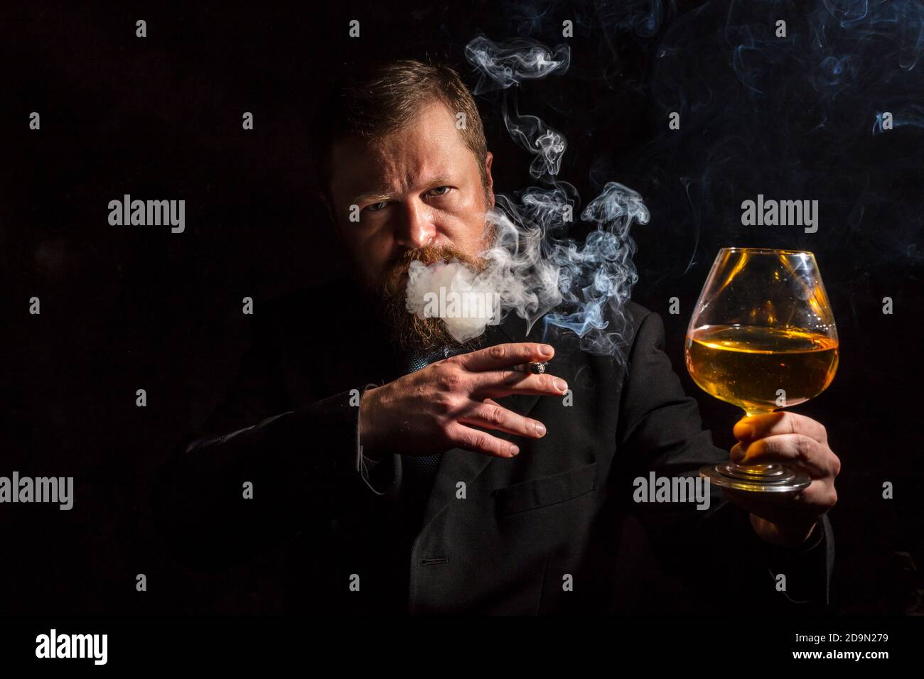 Solid confident bearded man in suit with glass of whisky and cigar with ...