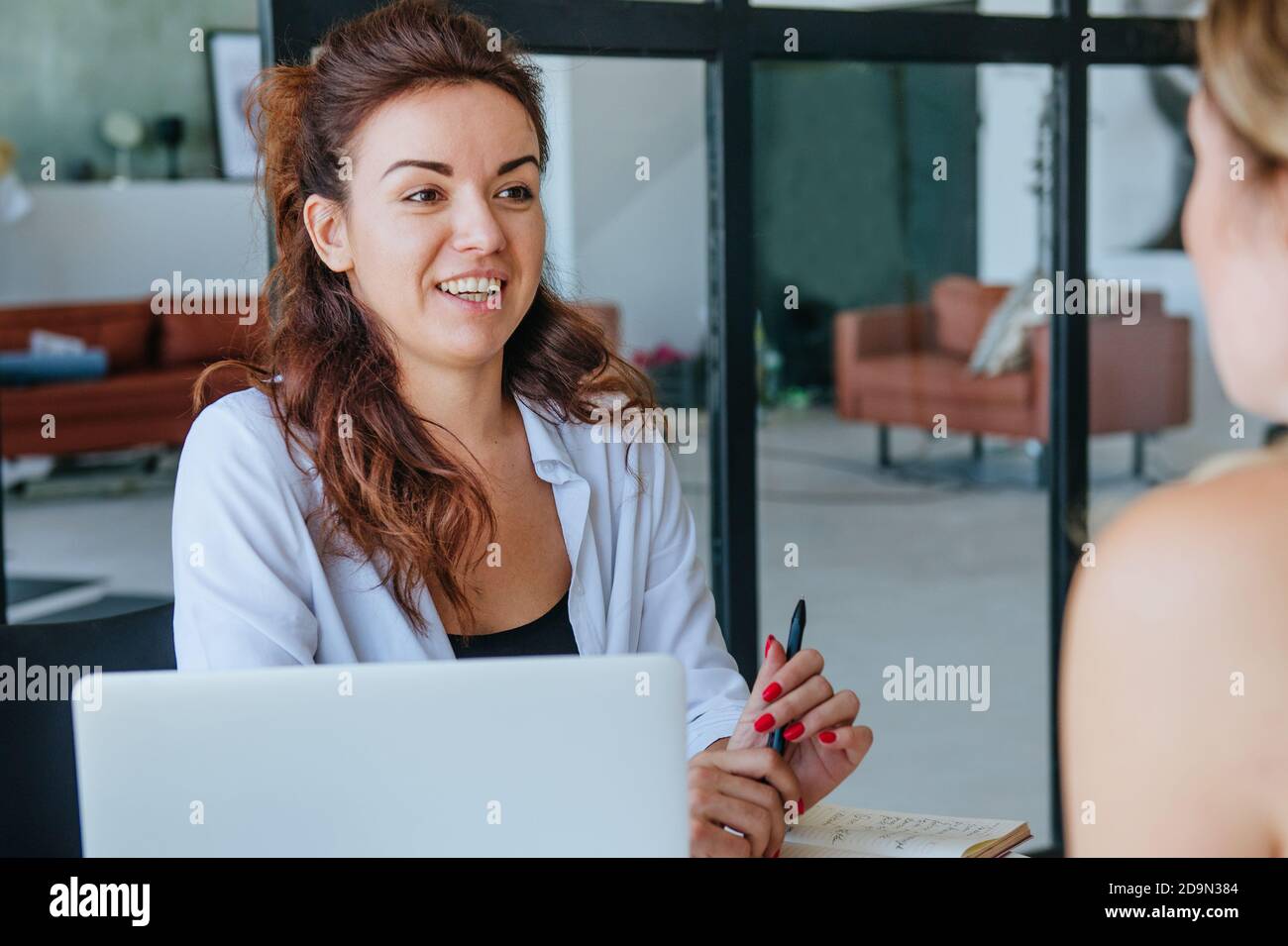 Female coach is consulting young woman indoor Stock Photo - Alamy