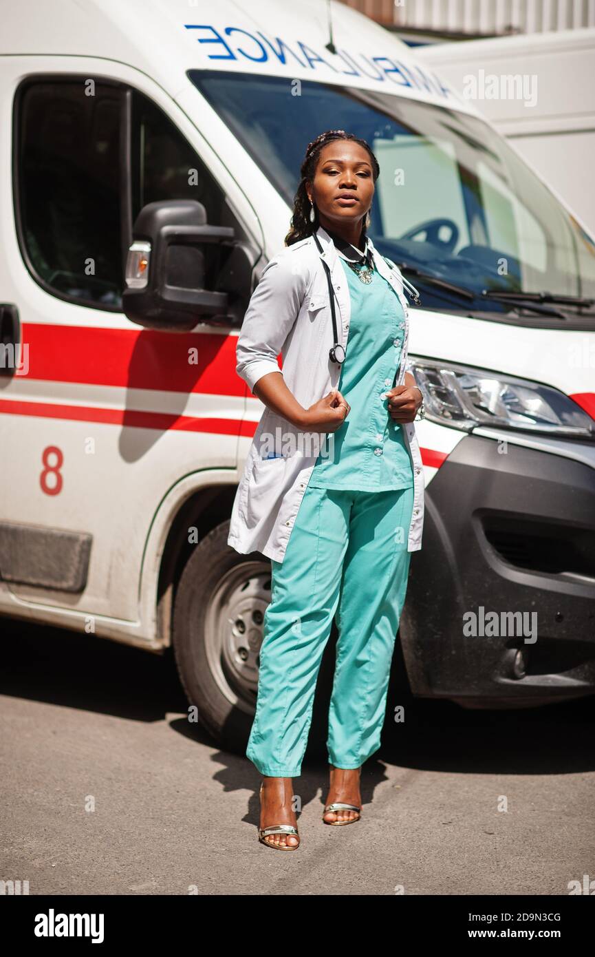 African american female paramedic standing in front of ambulance car ...