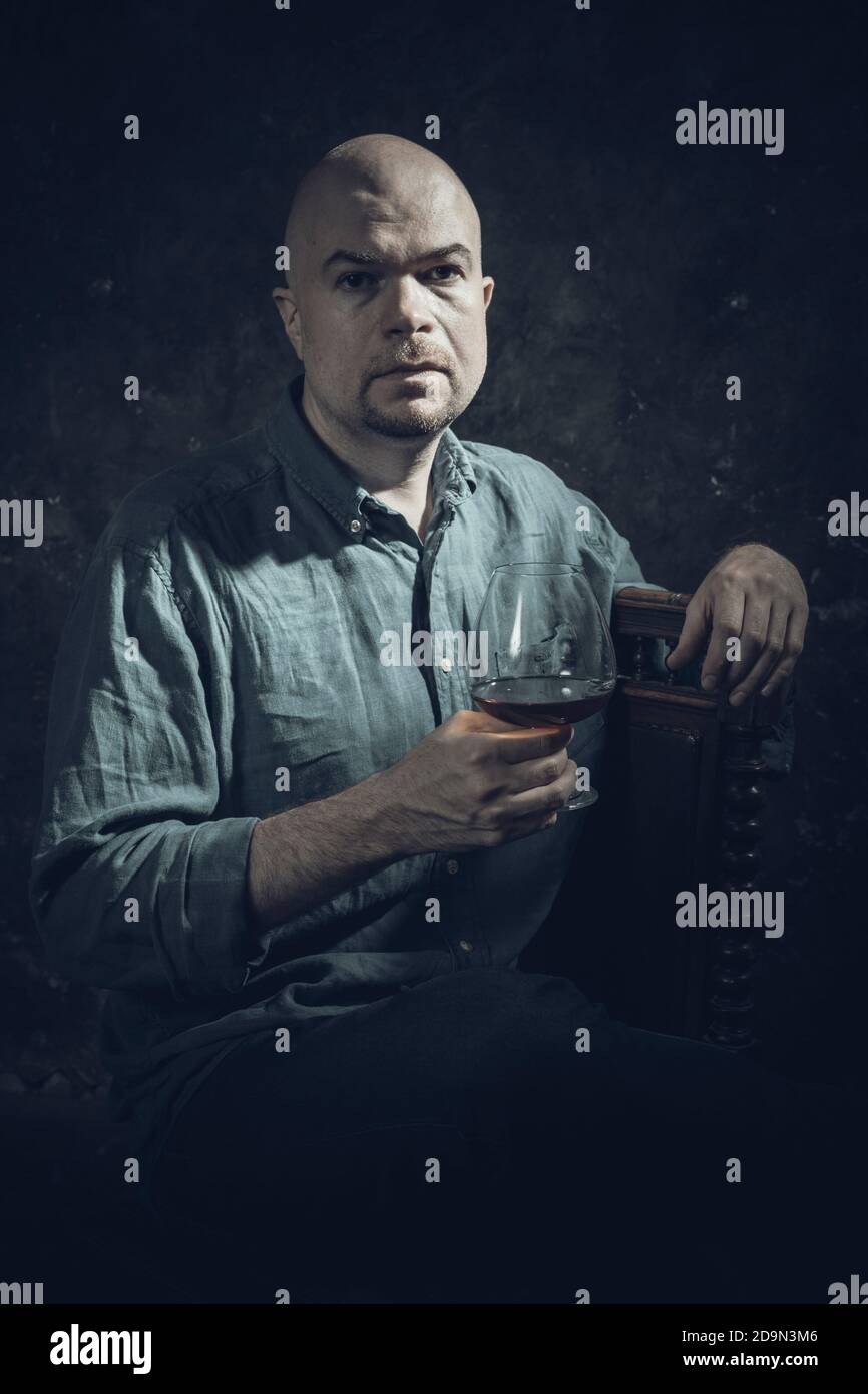 Solid bald man in shirt with glass of whisky studio portrait Stock ...
