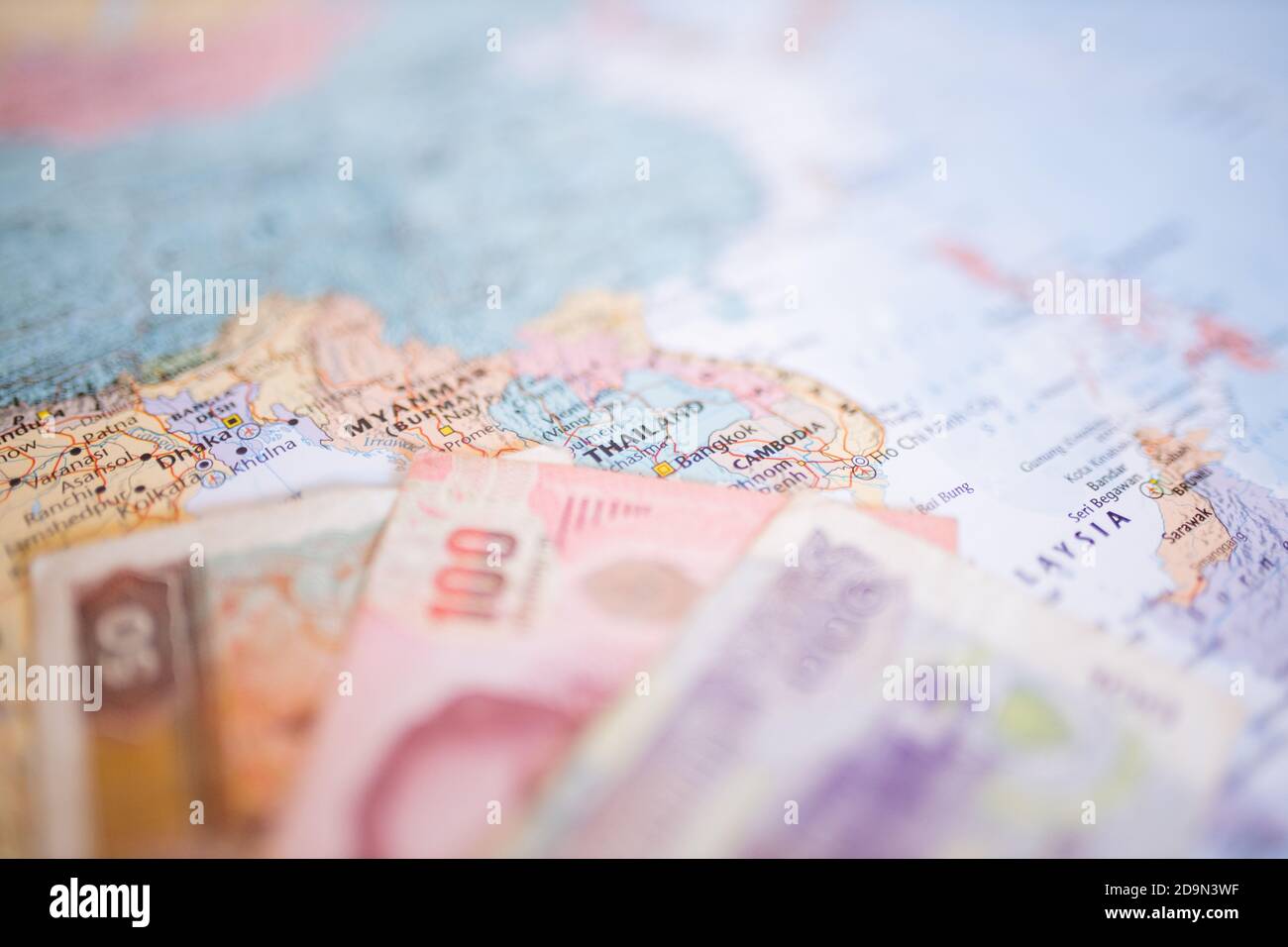 50 kyat bill, 100 baht bill, and a 100 riels bill on a map of Southeast ...
