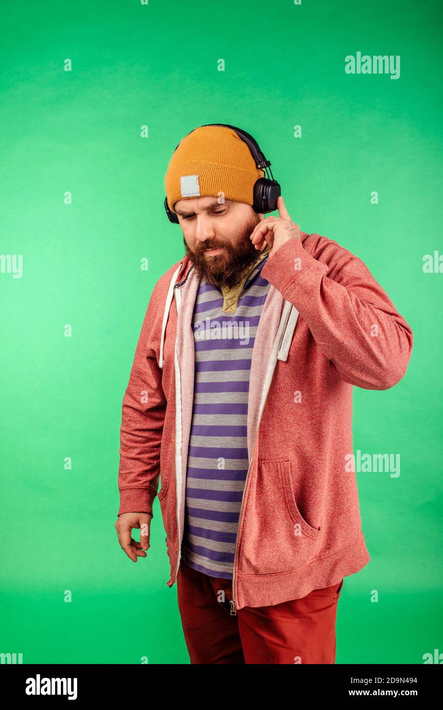 Portrait of a bright man posing in the studio on a green background ...