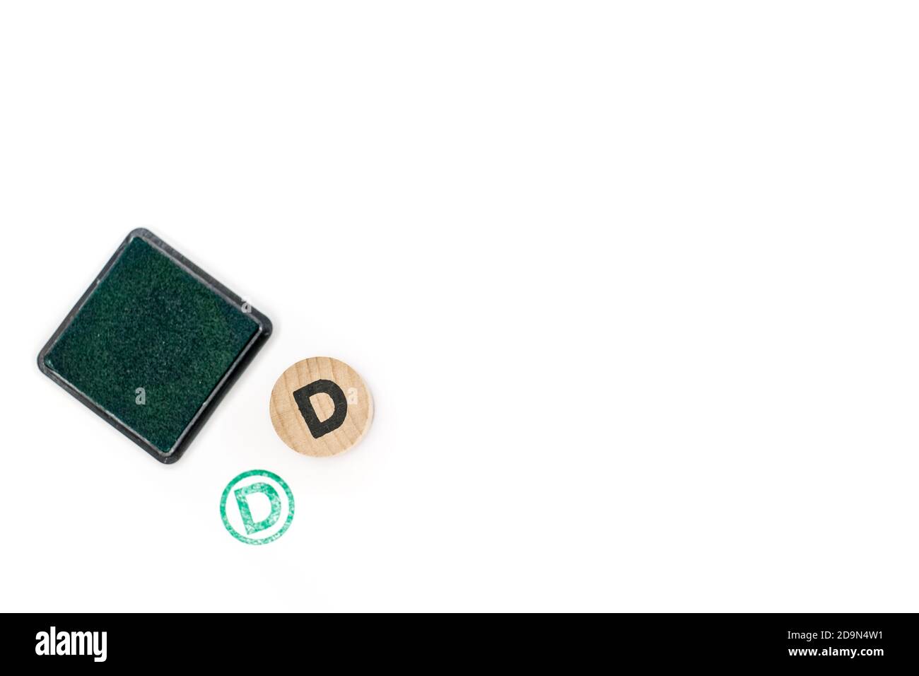 round wooden stamp letter D stamped and pad with green ink Stock Photo ...