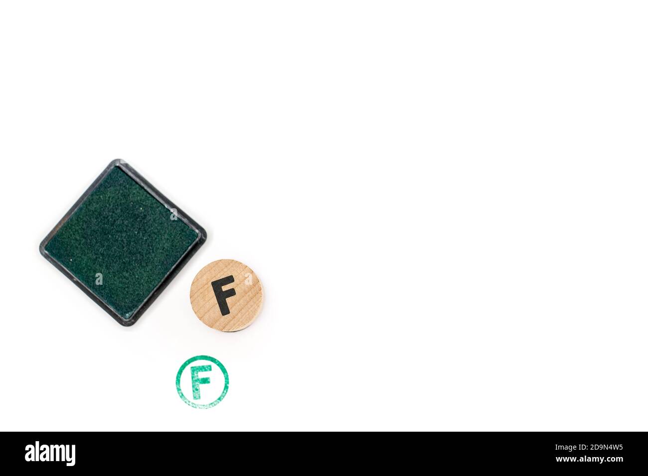 round wooden stamp letter F stamped and pad with green ink Stock Photo ...
