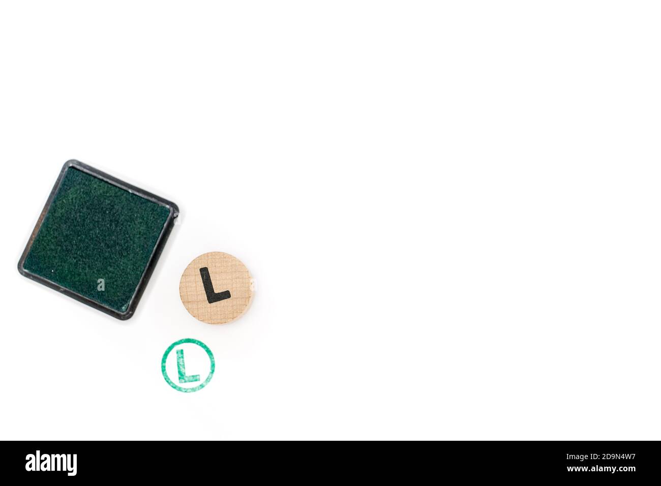 round wooden stamp letter L stamped and pad with green ink Stock Photo ...