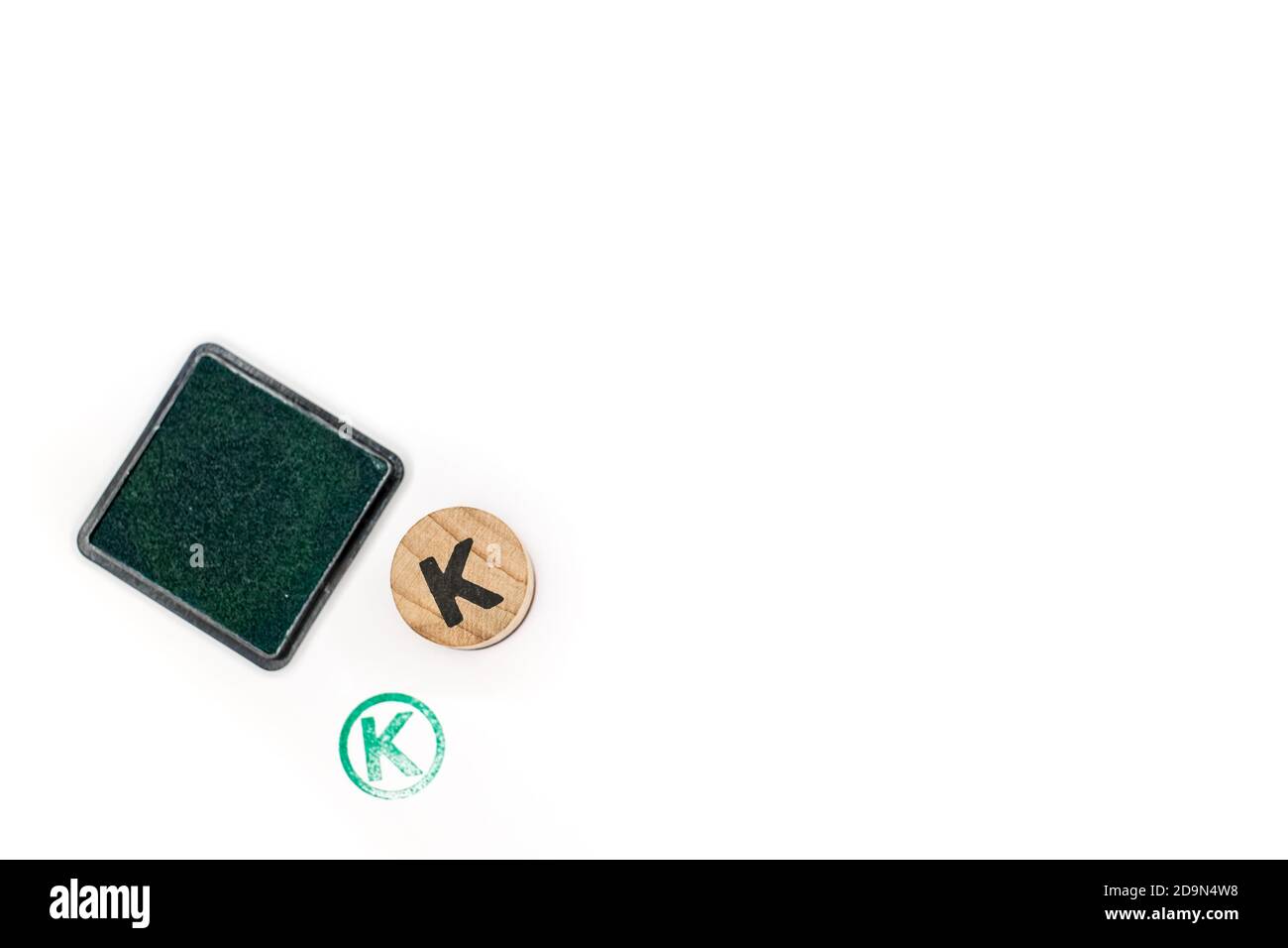 round wooden stamp letter K stamped and pad with green ink Stock Photo ...