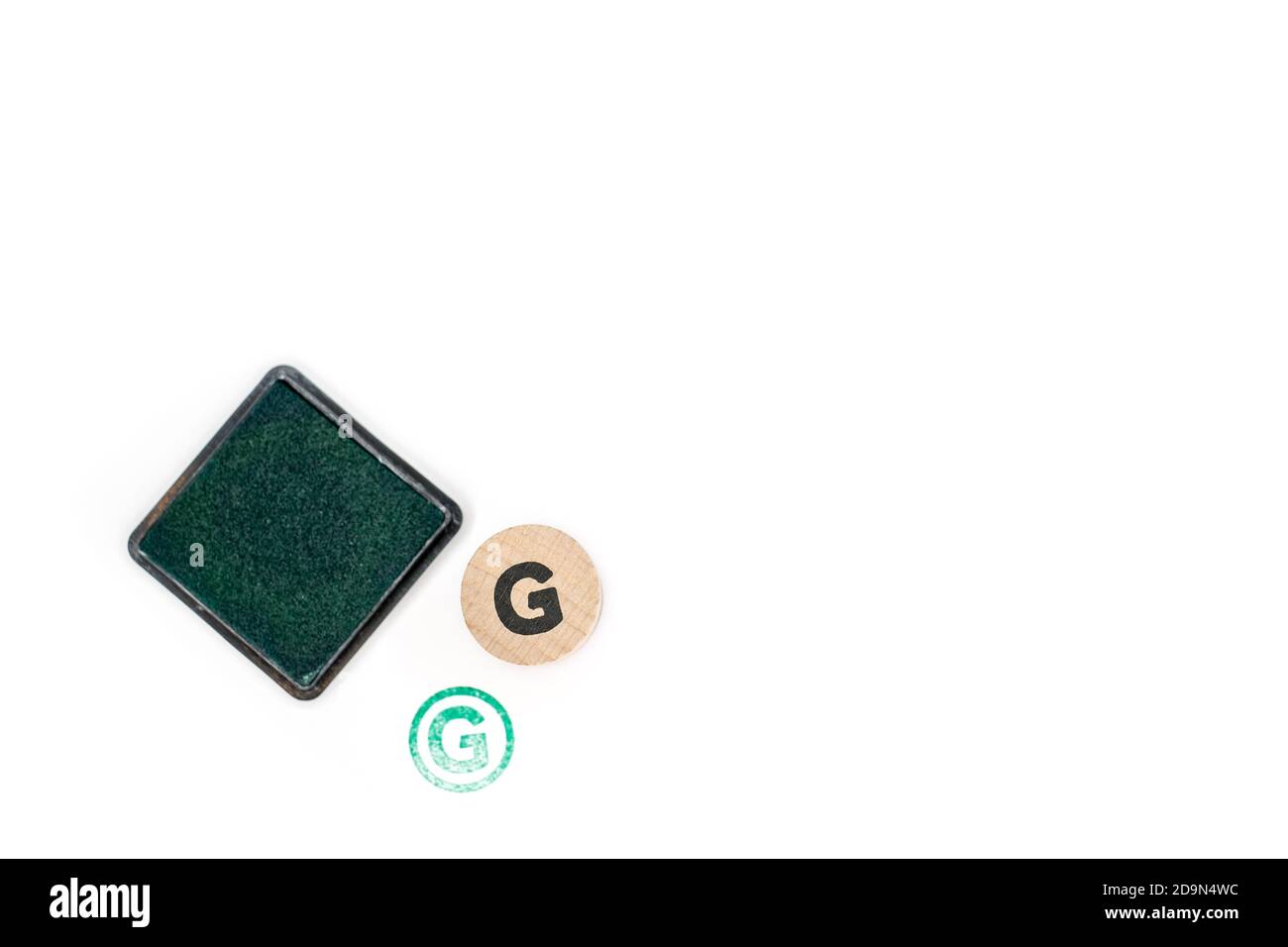 round wooden stamp letter G stamped and pad with green ink Stock Photo ...