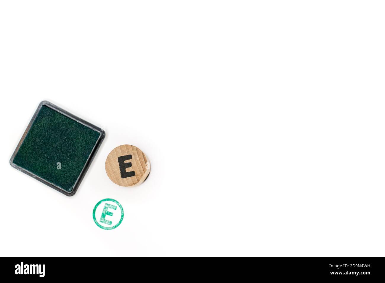 round wooden stamp letter E stamped and pad with green ink Stock Photo ...