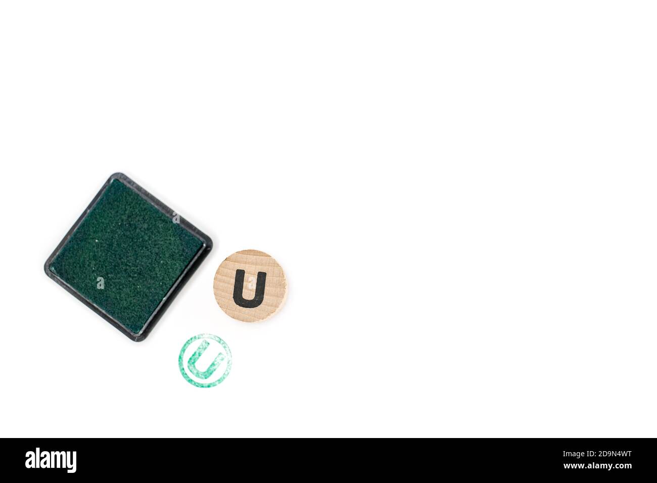 round wooden stamp letter U stamped and pad with green ink Stock Photo ...