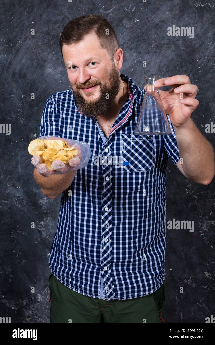 Solid bearded man at casual clothes with heap of chips in one hand and ...