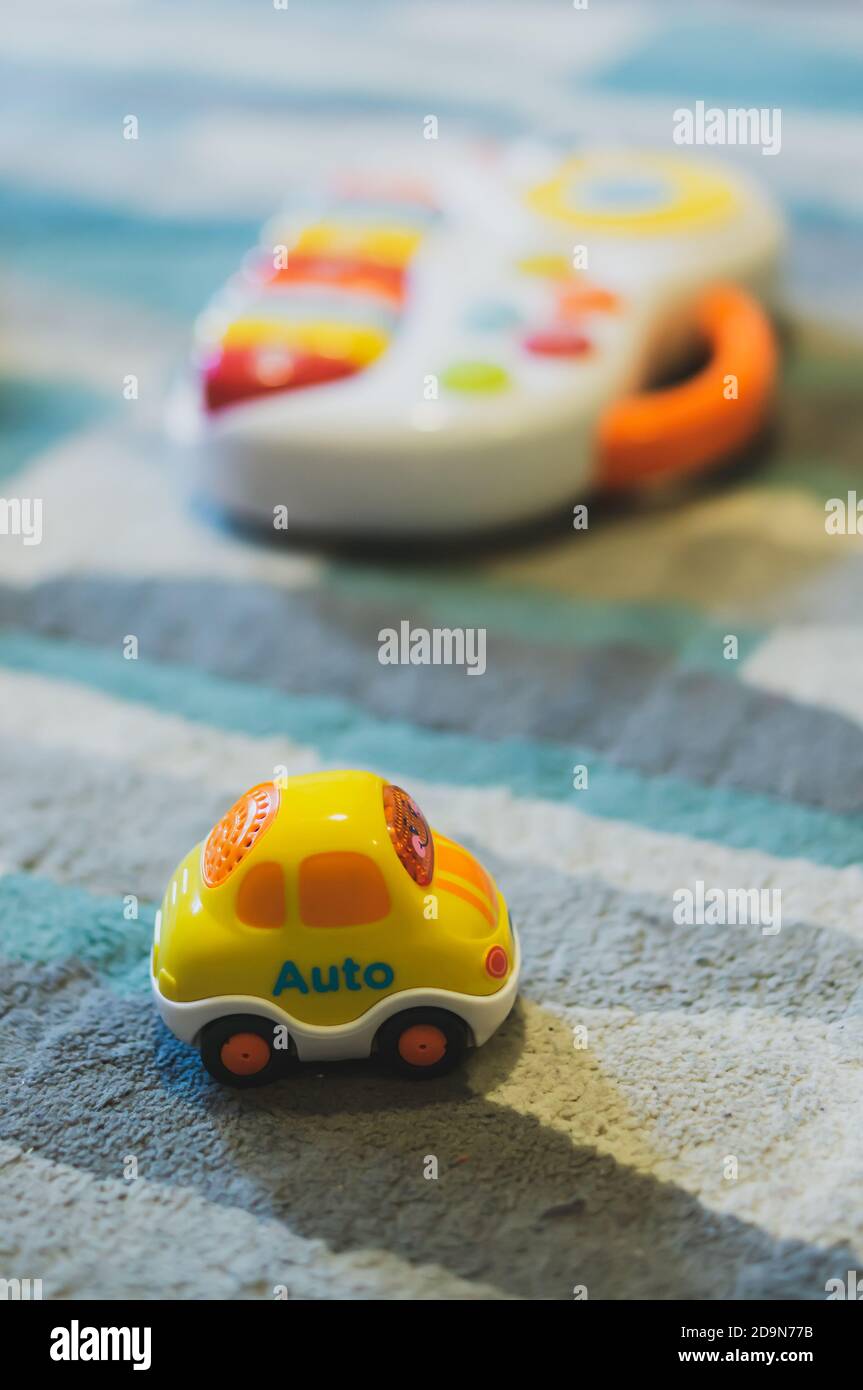 POZNAN, POLAND - Oct 27, 2018: Small yellow plastic toy car on a carpet ...