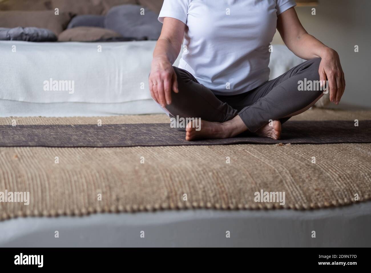 Woman sitting on mat resting after practice Stock Photo - Alamy