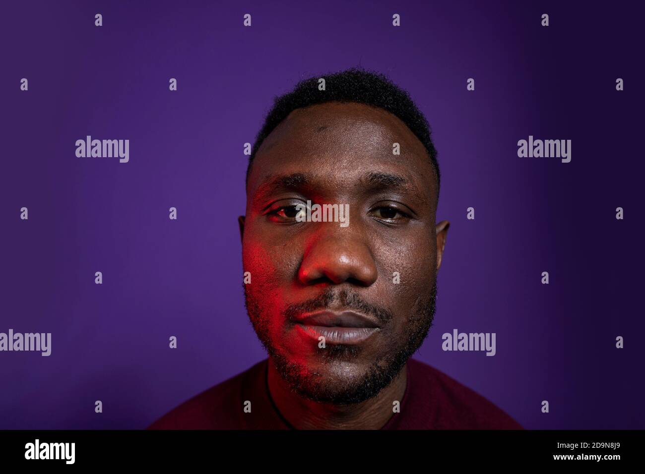 Face of black man looking at camera with blank facial expression. Close ...