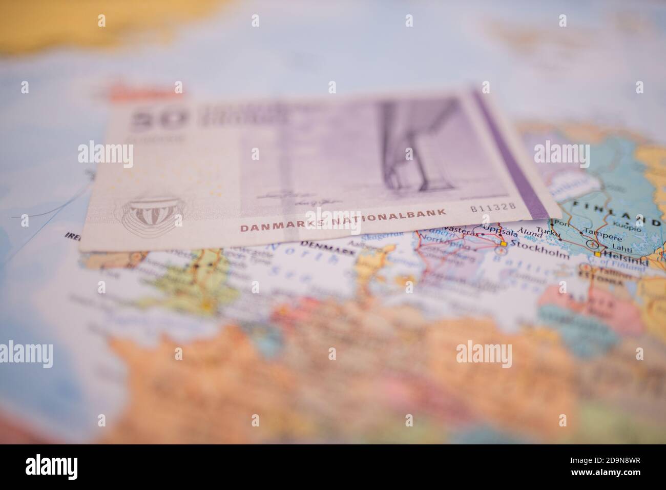 Fifty Danish kroner bill above Denmark on a colorful and blurry map of ...